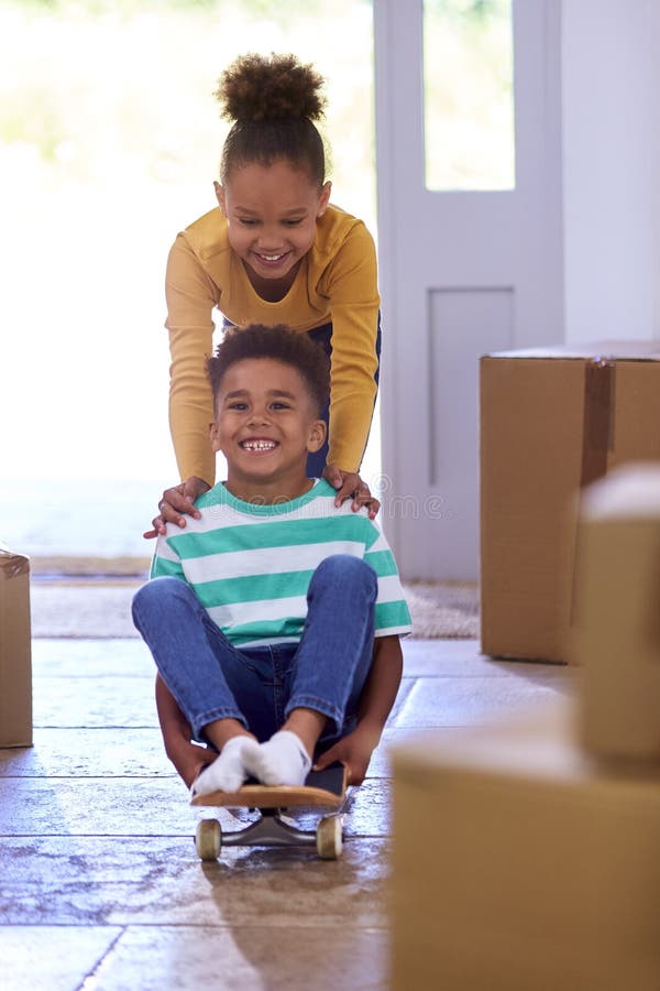 Two Children with Boxes on Moving in Day Playing on Skateboard Stock ...