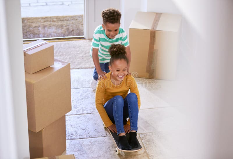 Two Children with Boxes on Moving in Day Playing on Skateboard Stock ...
