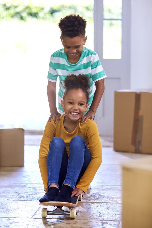 Two Children with Boxes on Moving in Day Playing on Skateboard Stock ...