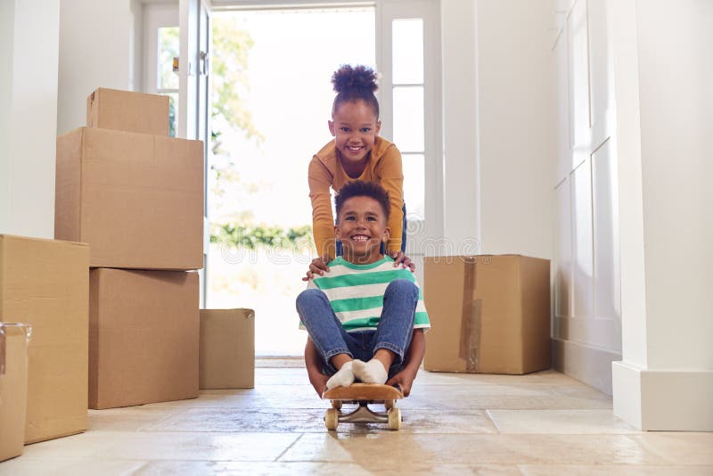 Two Children with Boxes on Moving in Day Playing on Skateboard Stock ...