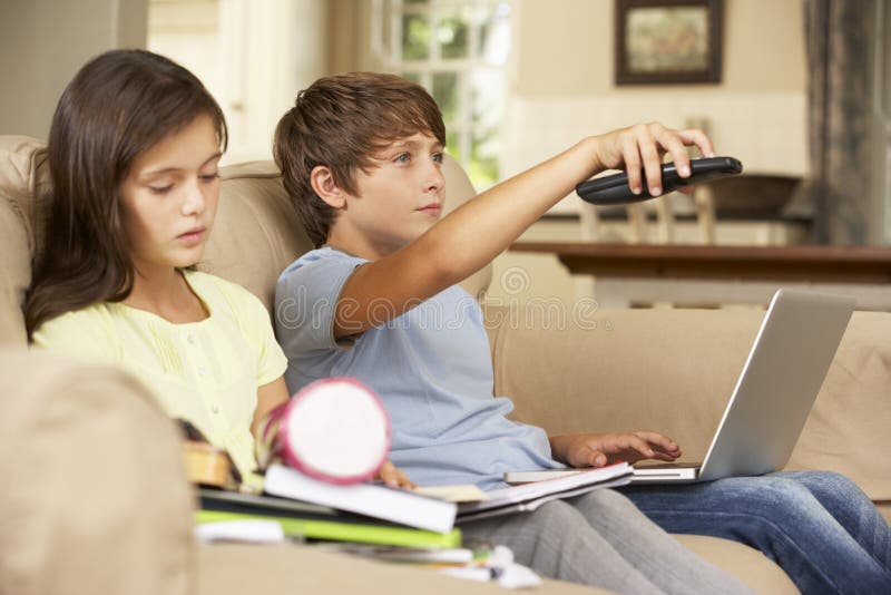 Two Children Distracted By Television Whilst Trying To Do With Homework ...