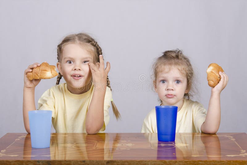 Two Children Eat a Muffin at the Table Stock Image - Image of table ...