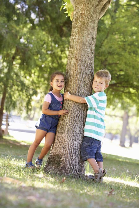Two Children Hugging Tree in Park Stock Photo - Image of sunny, female ...