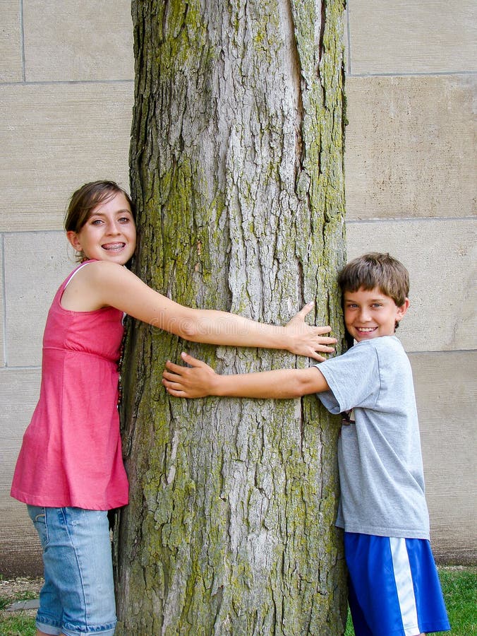 Two Smiling Children Hugging a Tree in an Urban Setting Stock Photo ...