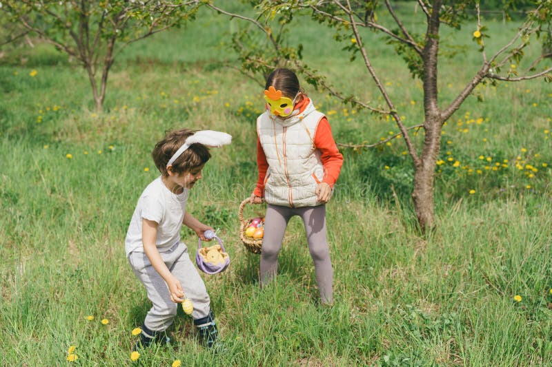 Two Children Hunt for Easter Eggs in a Spring Garden. Easter Tradition ...