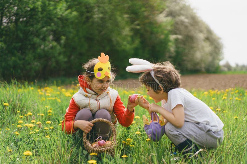 Two Children Hunt for Easter Eggs in a Spring Garden. Easter Tradition ...