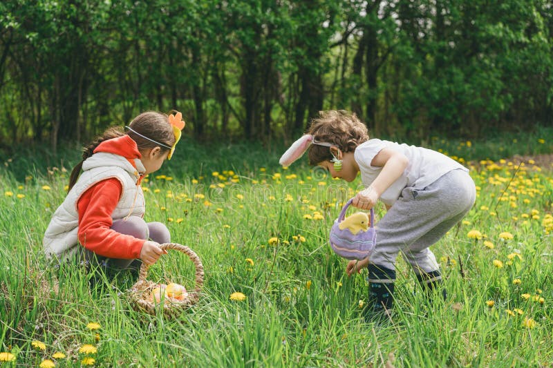 Two Children Hunt for Easter Eggs in a Spring Garden. Easter Tradition ...