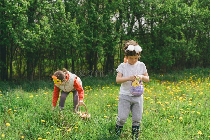 Two Children Hunt for Easter Eggs in a Spring Garden. Easter Tradition ...