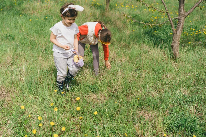Two Children Hunt for Easter Eggs in a Spring Garden. Easter Tradition ...