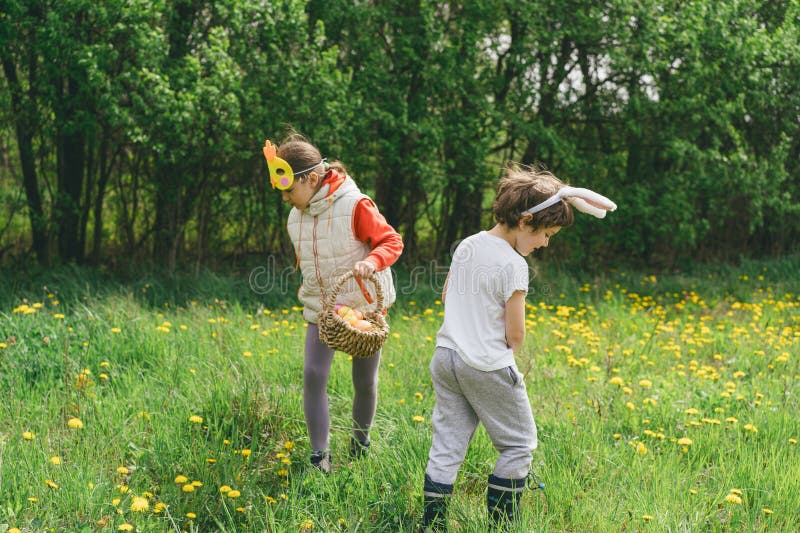Two Children Hunt for Easter Eggs in a Spring Garden. Easter Tradition ...