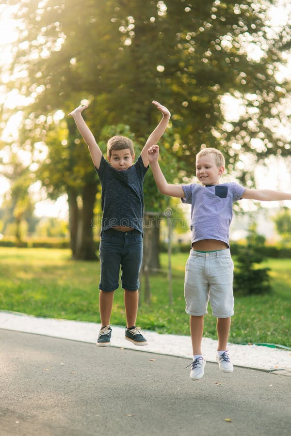 Two Children are Jumping Up in the Air Stock Photo - Image of boys ...
