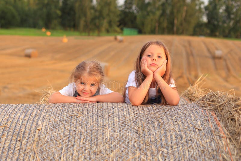 Beautiful Little Girl Stands Near a Haystack in a Summer Field Stock ...
