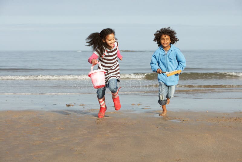 Two Children Playing by Sea on Winter Beach Stock Photo - Image of ...