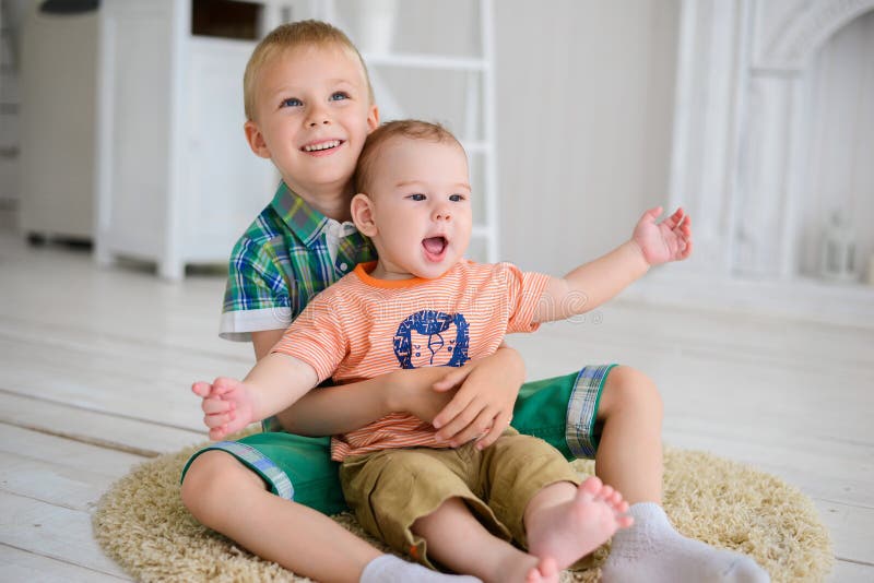 Two Children are Playing while Sitting on the Floor at Home Stock Photo ...