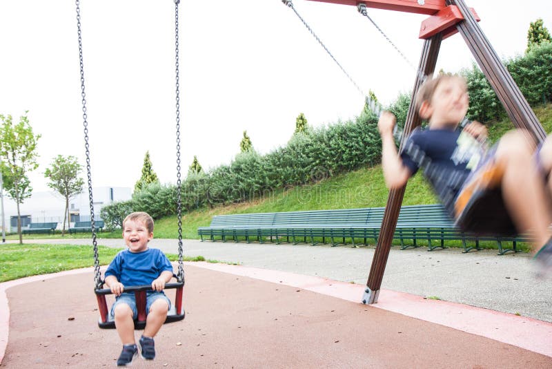 Two Children Playing in the Swing Stock Image - Image of playing ...