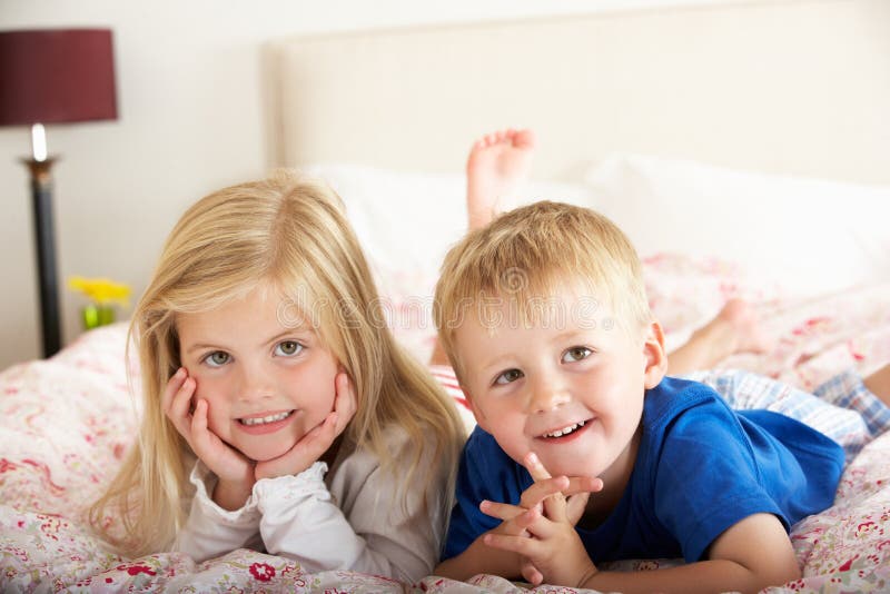 Two Children Relaxing on Bed Stock Image - Image of pyjamas, happy ...