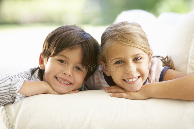 Two Children Relaxing on Sofa at Home Stock Photo - Image of home ...