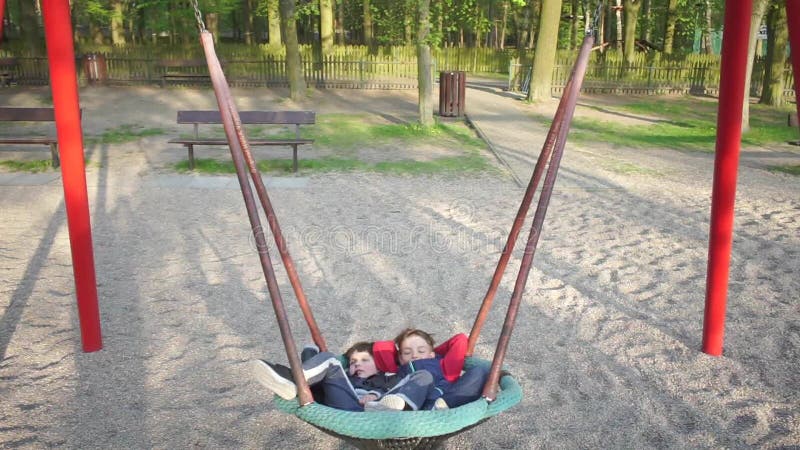 Two Children Ride on a Swing at the School Site Stock Video - Video of ...