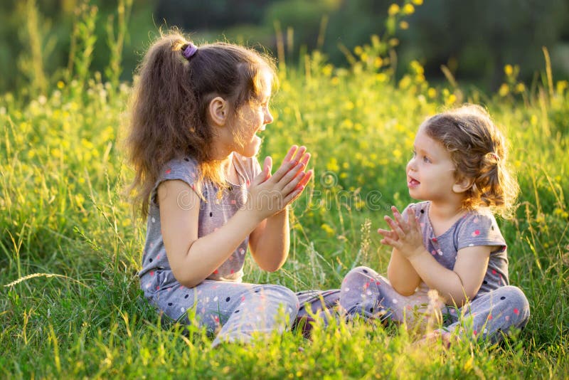 Two Children Talking and Having Fun on the Grass. Stock Photo - Image ...