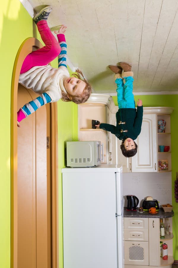 Two Children Upside Down on the Ceiling of Kitchen Stock Photo - Image ...