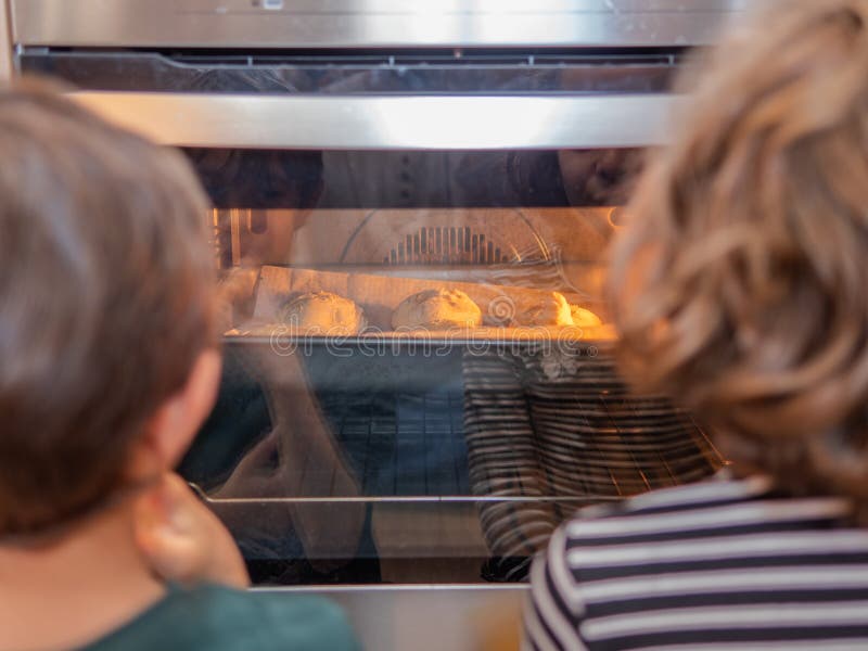 Two Children Watching Baked Goods Rise in Oven Stock Photo - Image of ...