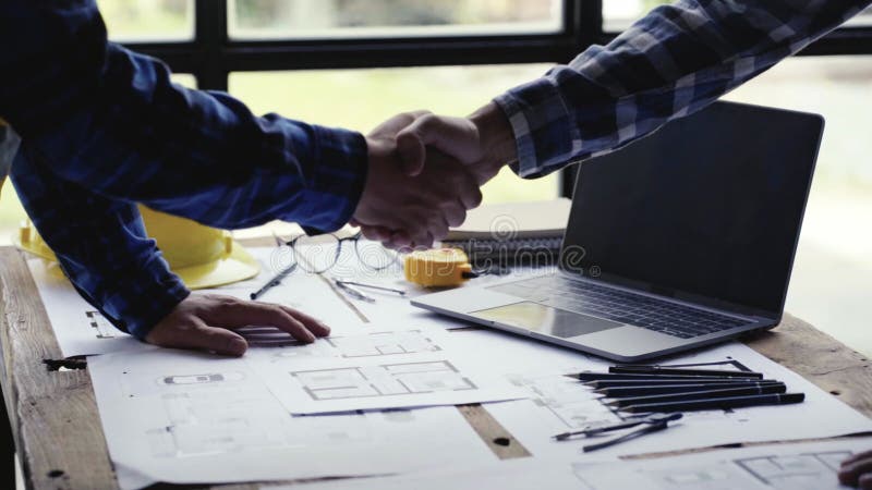 Two Civil Engineer or Architect Holding Helmet and Handshaking after a ...