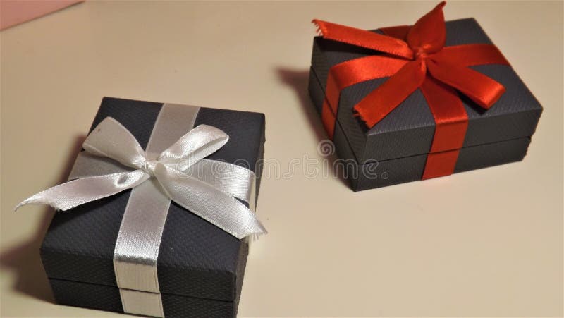 Two Red Ring Boxes with a Rings in Them and a Necklace Near Them are ...