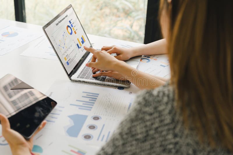 Two Colleagues Analyzing Financial Data Reports on Laptop with Charts ...