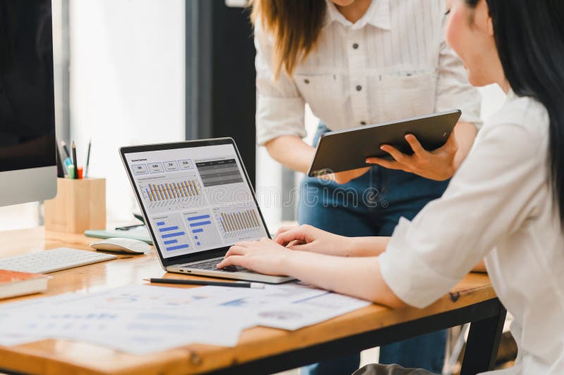 Two Colleagues Analyzing Financial Data Reports on Laptop with Charts ...