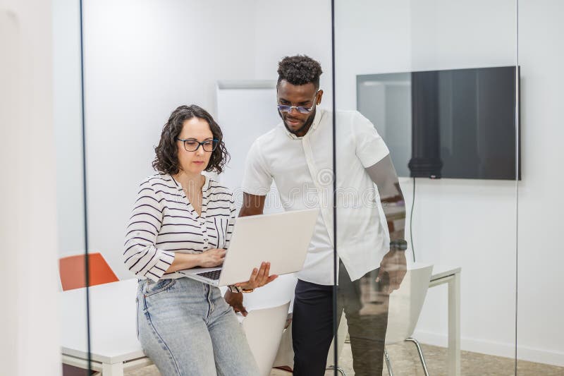 Two Colleagues Collaborating on Laptop in Modern Office Space Stock ...
