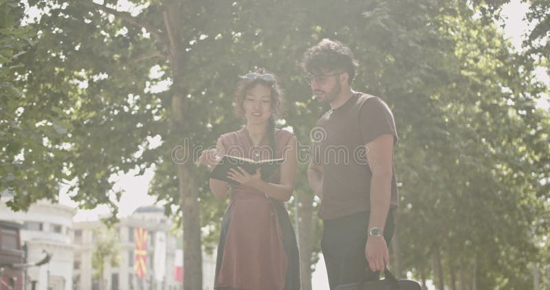 Two Colleagues Conversing about Work while Standing Under a Tree ...