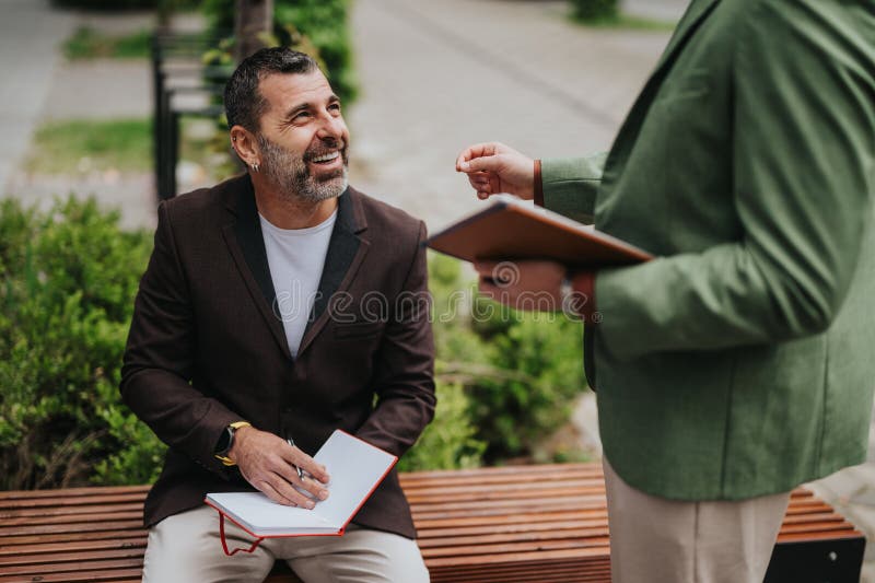 Two Colleagues Discussing Notes while Sharing Ideas in an Outdoor ...