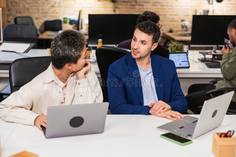 Multi Ethnic Colleagues Collaborating on Project Using Laptops in ...