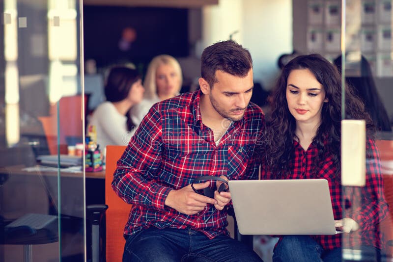 Two Colleagues Discussing Work on a Laptop. Stock Photo - Image of ...