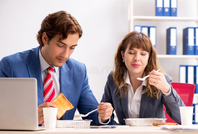 Two Colleagues Having Lunch Break at Workplace Stock Photo - Image of ...