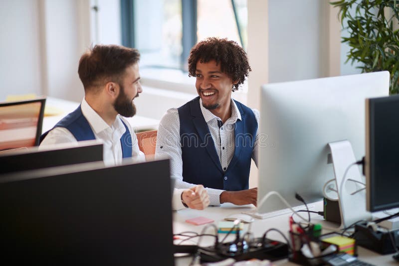 Two Colleagues, Multiethnic, Talking and Smiling at the Office ...