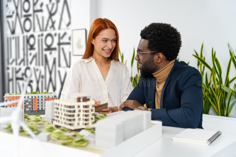 Two Colleagues Sitting at the Table in the Office and Discussing ...