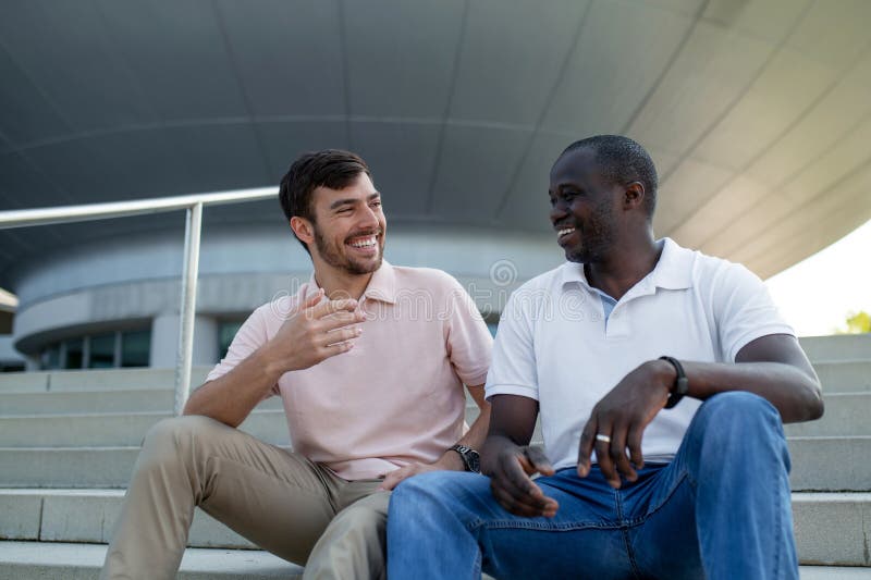 Two Colleagues Sitting Together on Steps and Talking Stock Image ...