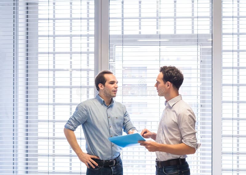 Two Colleagues Speaking Together about Project Standing in Bright ...