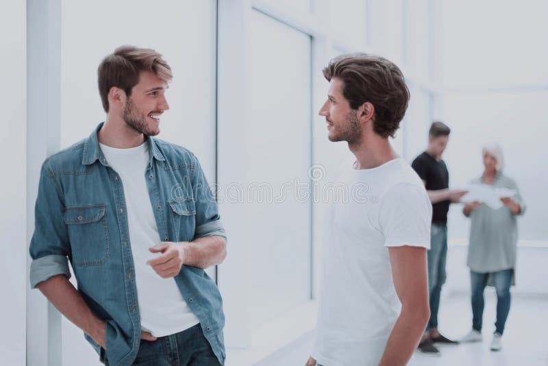Two Colleagues Talking Standing in the Office Corridor Stock Photo ... Two Colleagues Talking Standing in the Office Corridor Stock Photo ...