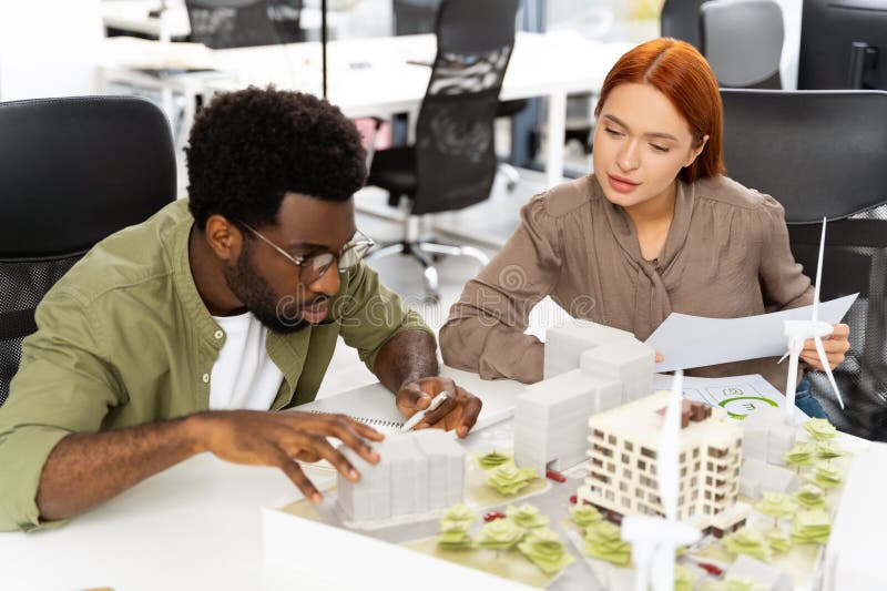 Two Colleagues Working in the Office on a New Sustainable Project Stock ...