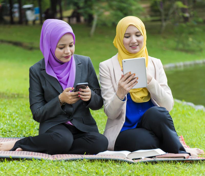 Two College Students Busy Texting with Their Smartphone while Resting ...