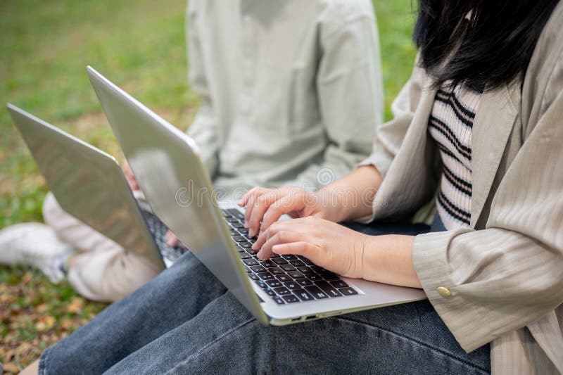 Two College Students Collaborating on Work and Using Their Laptop ...