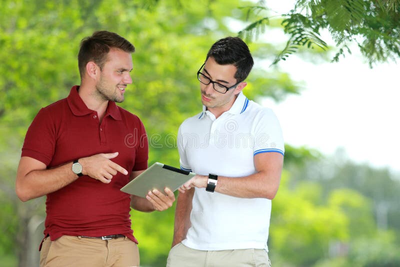 Two College Students Discussing an Assignment Using Tablet Stock Image ...