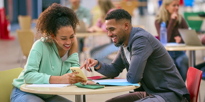 Two College or University Students with Mobile Phone Working Together ...