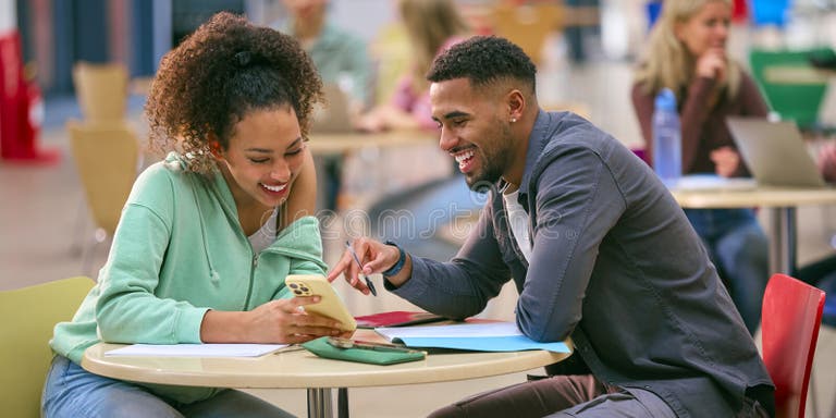 Two College or University Students with Mobile Phone Working Together ...