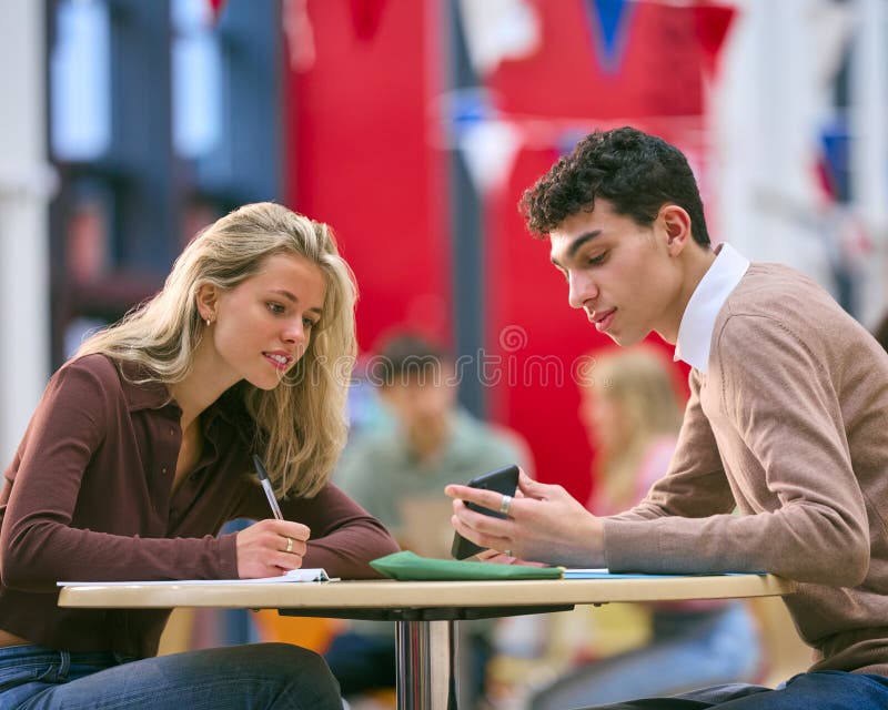 Two College or University Students with Mobile Phone Working Together in Study Area Stock Photo ...