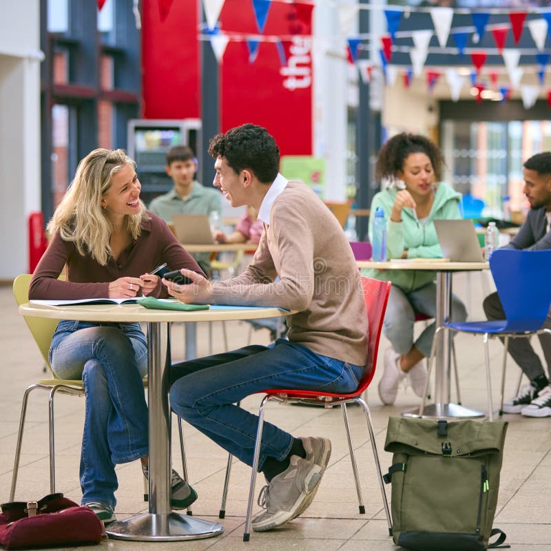 Two College or University Students with Mobile Phone Working Together ...