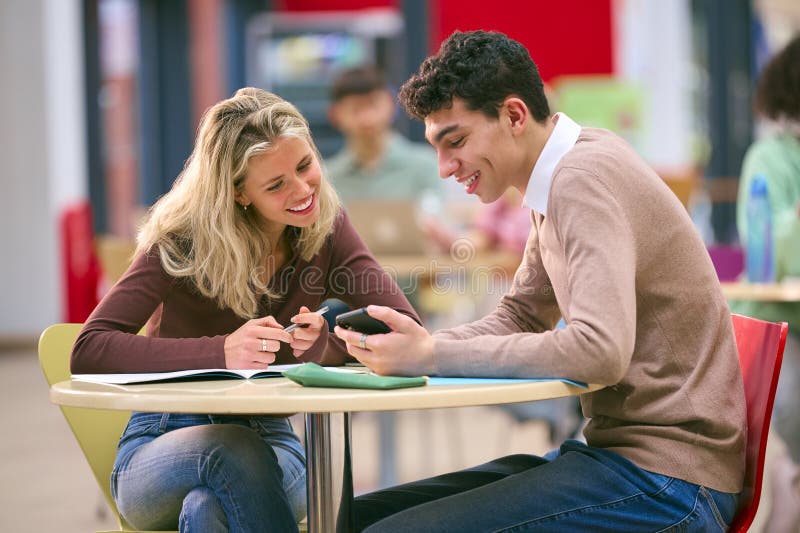Two College or University Students with Mobile Phone Working Together ...