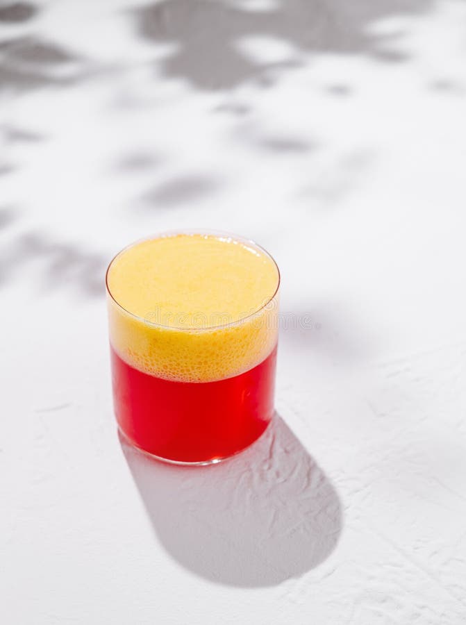 Two Colored Layered Cocktail is Standing on White Table with Shadows ...